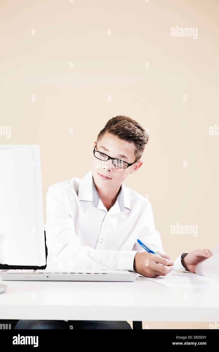 Boy working on a computer at his desk Stock Photo - Alamy