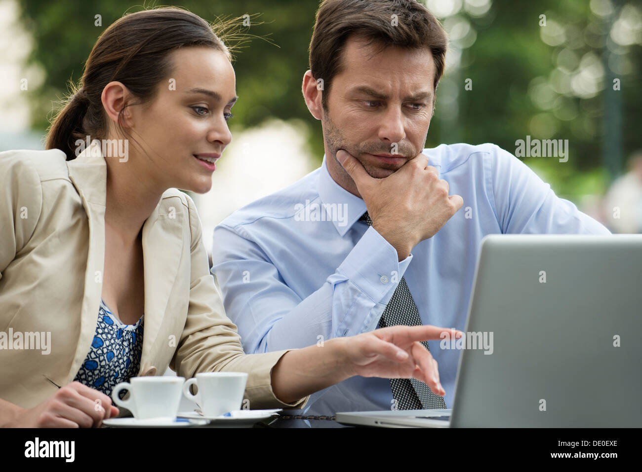 Business associates collaborating on project using laptop computer ...