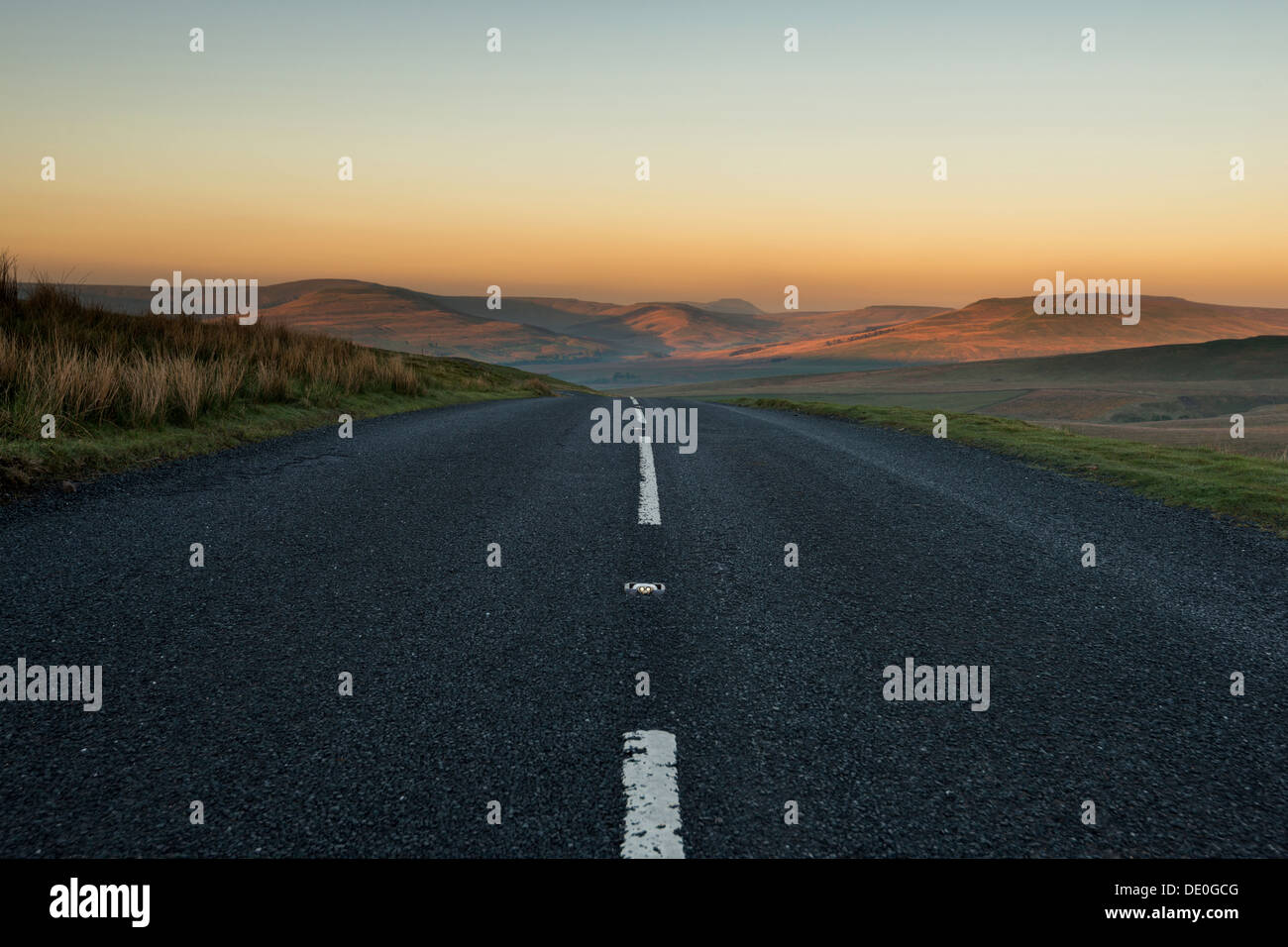 Road and hill at sunrise Stock Photo - Alamy