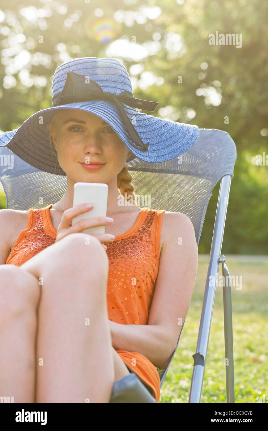 Woman sitting outdoors chair using cell phone hi-res stock photography ...