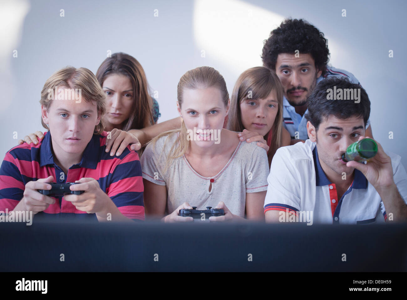 Friends playing video games together Stock Photo - Alamy