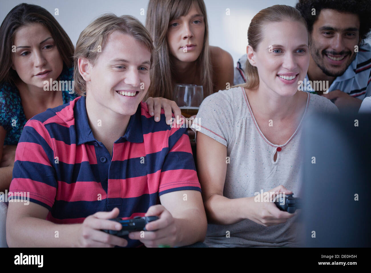 Friends playing video games together Stock Photo - Alamy