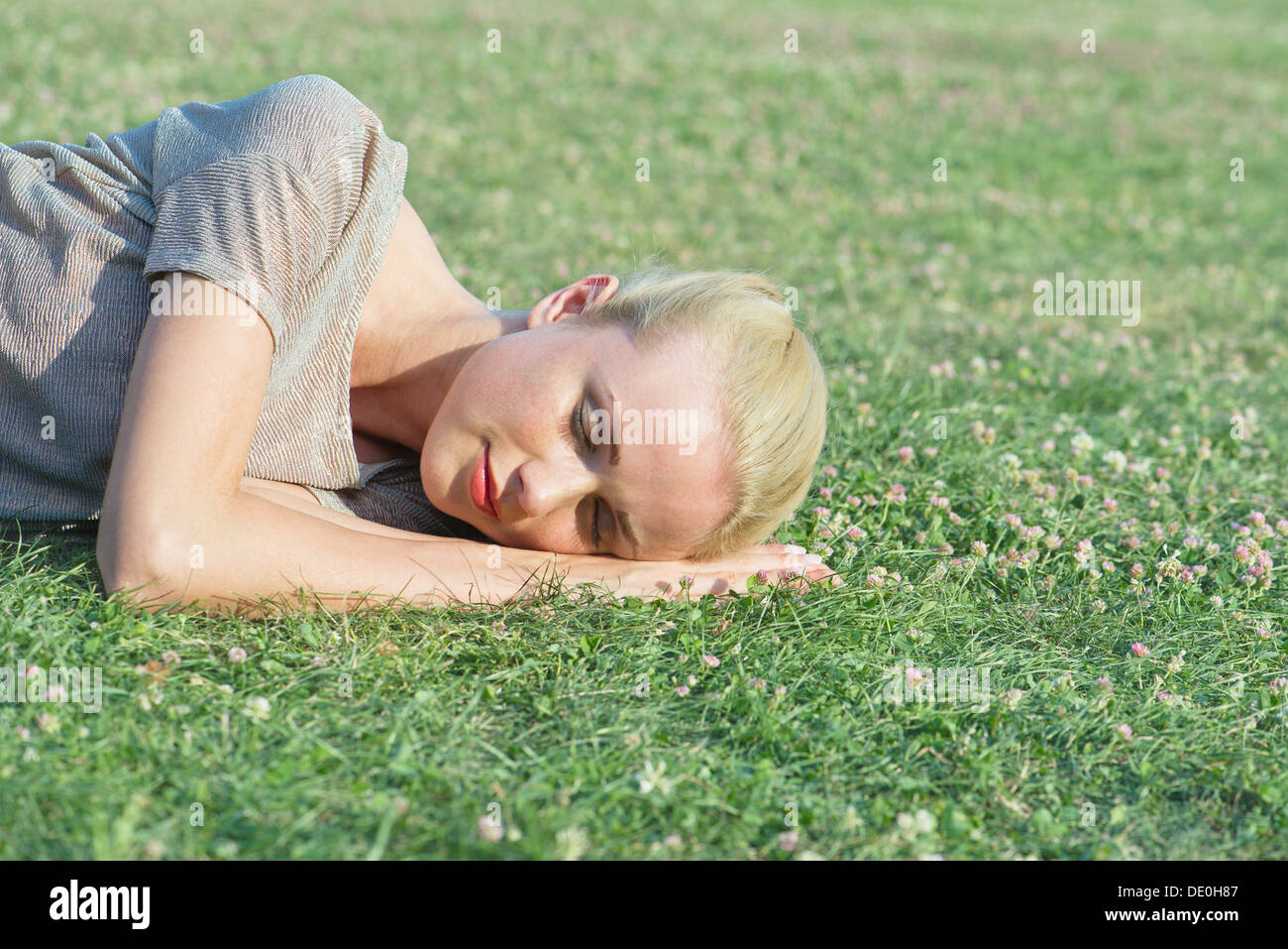 Woman taking nap on grass hi-res stock photography and images - Alamy