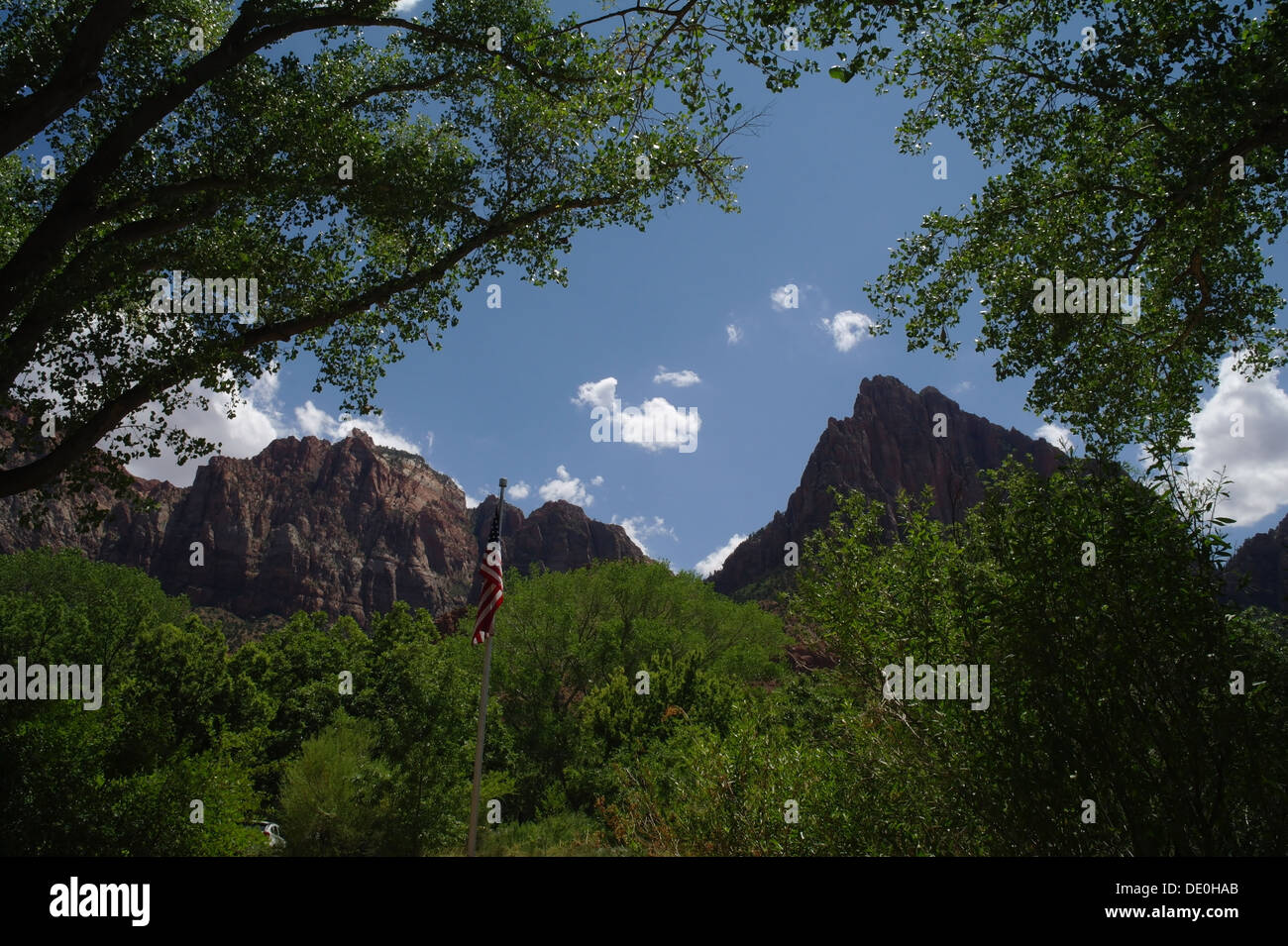 Blue sky view 'The Watchman' rising through green trees window with ...