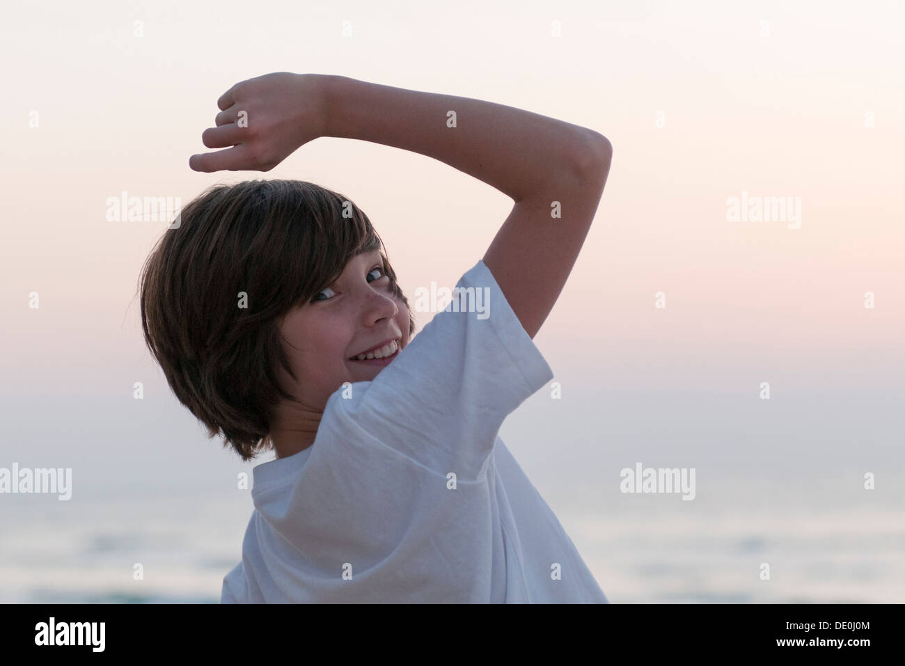 Teenage boy smiling over shoulder, portrait Stock Photo - Alamy