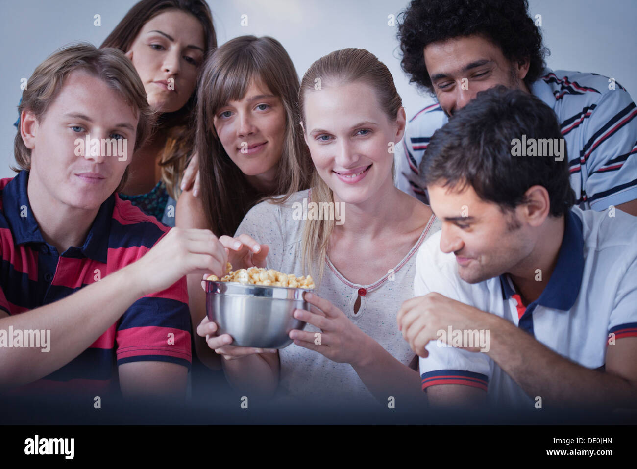 Friends sharing popcorn and watching movie together Stock Photo - Alamy