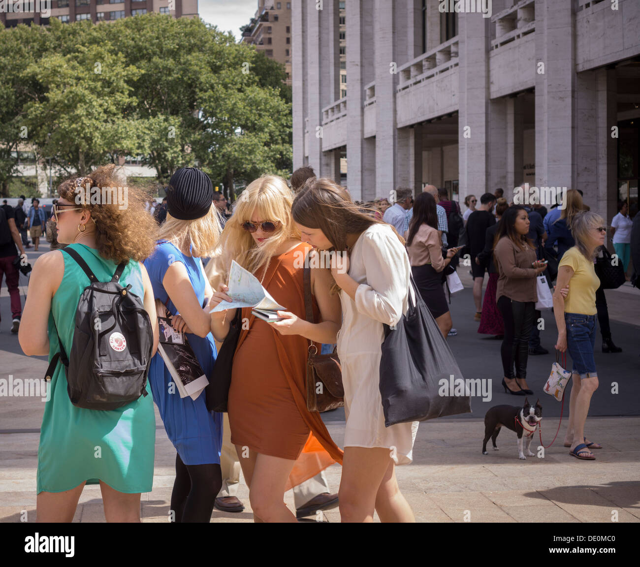 Crowds of fashionistas and photographers create a fashion scene outside ...