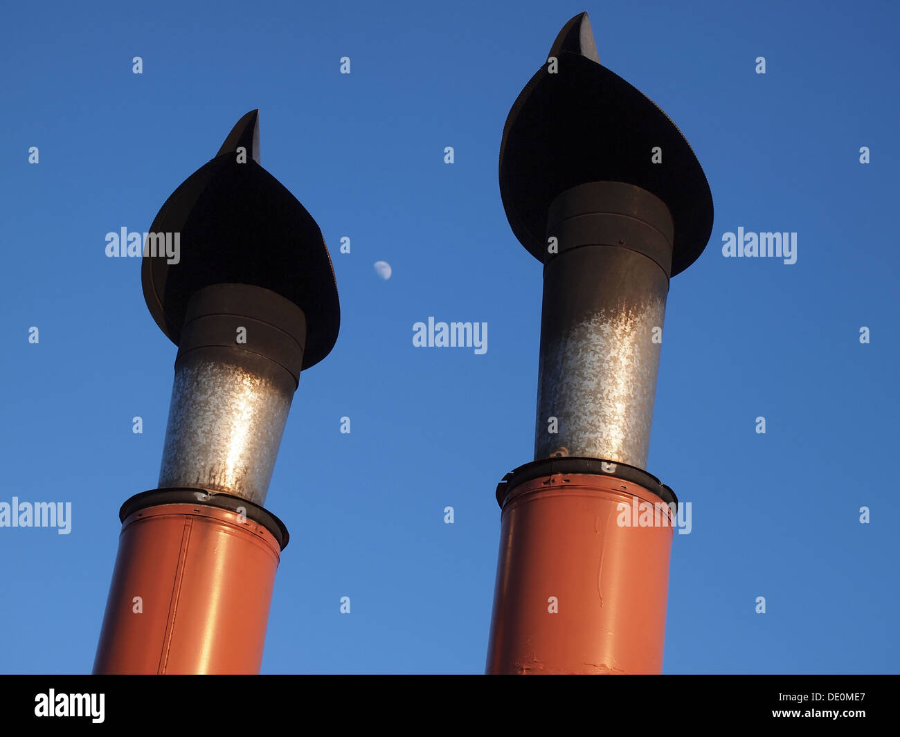 Chimney stacks and moon against blue sky, USA Stock Photo - Alamy