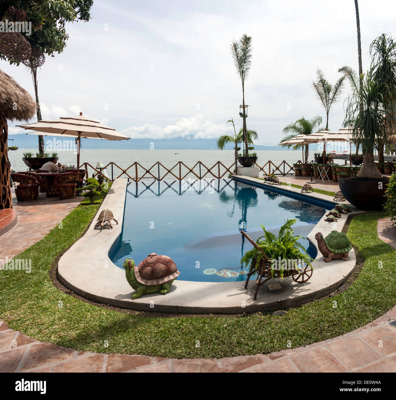 Lakeside patio garden with infinity pool decorated with small statues ...