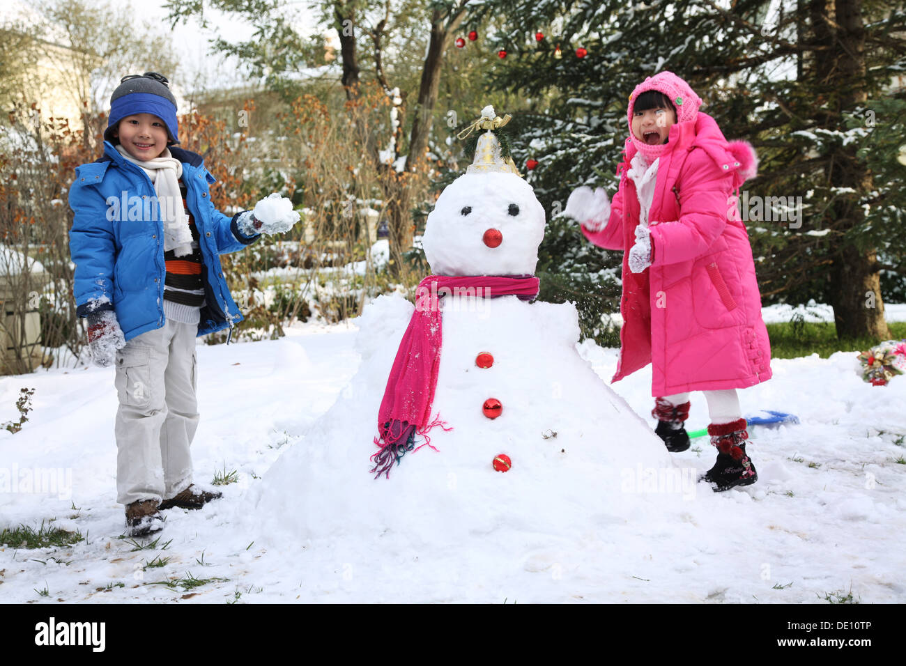 Children with snowman Stock Photo - Alamy