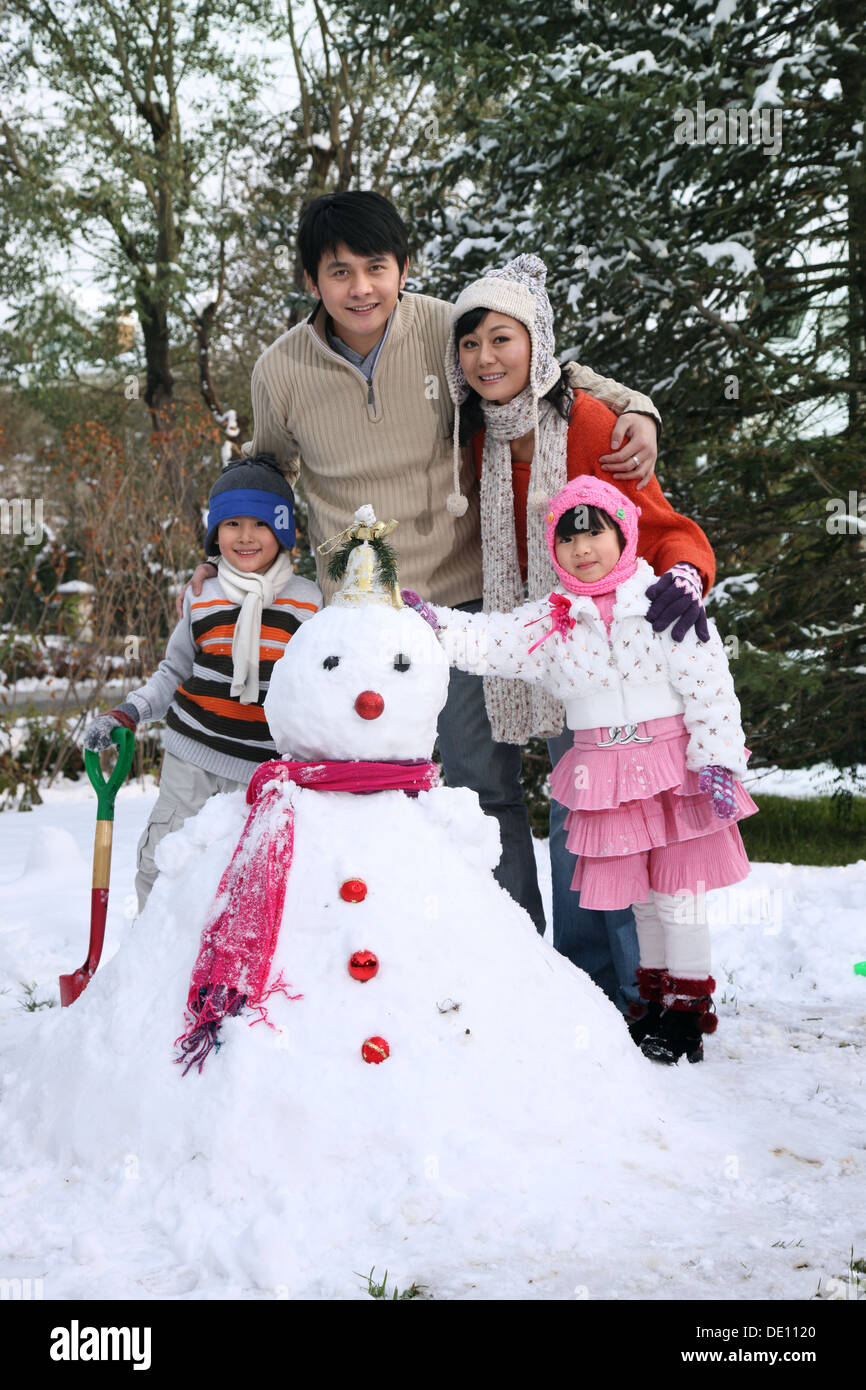 Family with snowman Stock Photo - Alamy