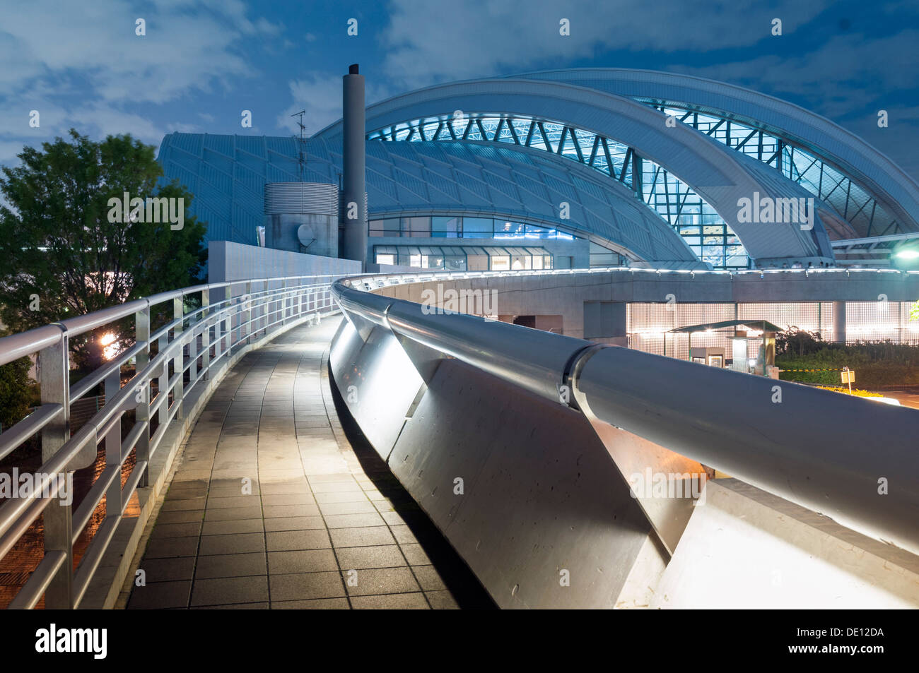 pedestrian pathway with metallic handrail leads toward modern arc dome ...