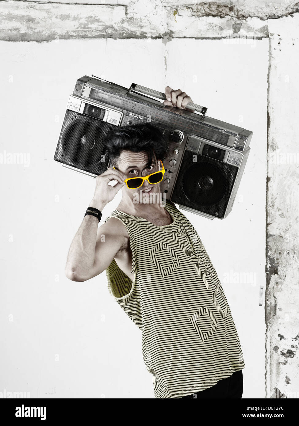 Foolish guy carrying a big portable old radio on his shoulder or on to ...