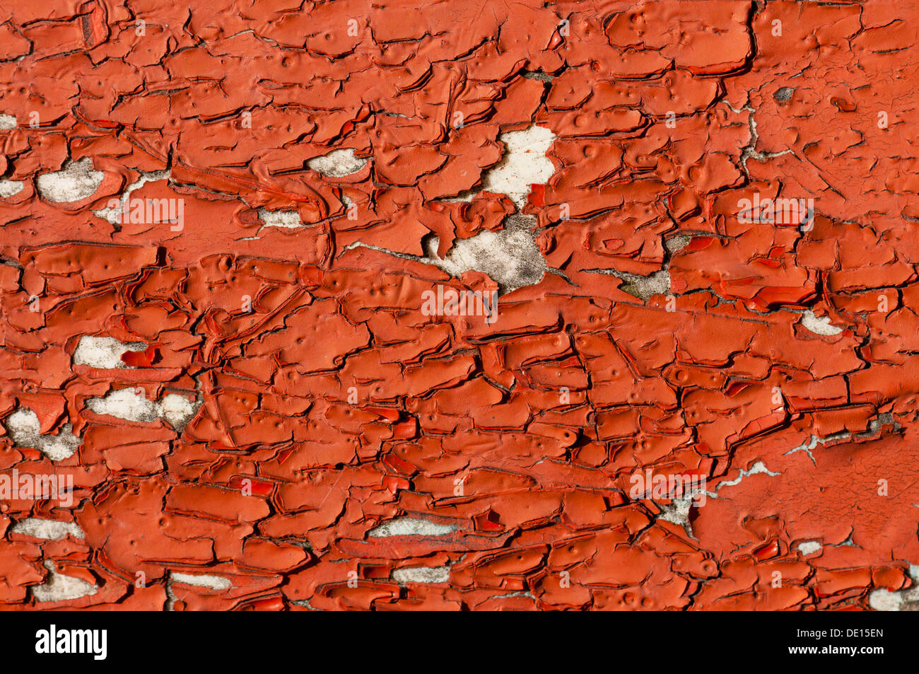 Surface with red paint coming off in flakes Stock Photo - Alamy