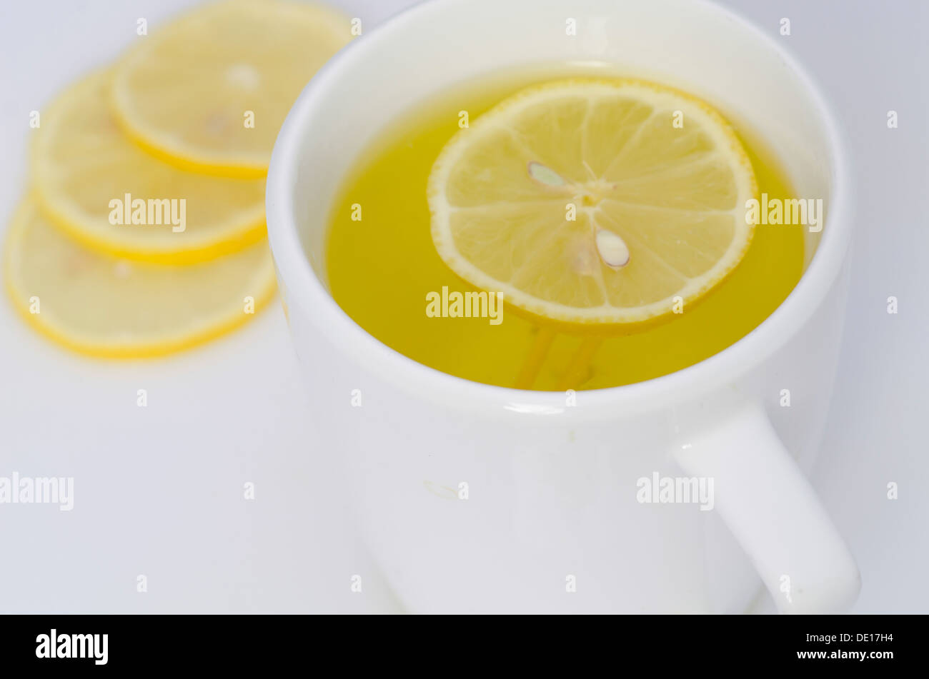 Mug of hot lemon tea with three thin slices of lemon displayed on a ...