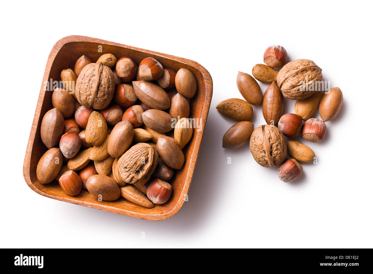various unpeeled nuts in wooden bowl on white background Stock Photo ...