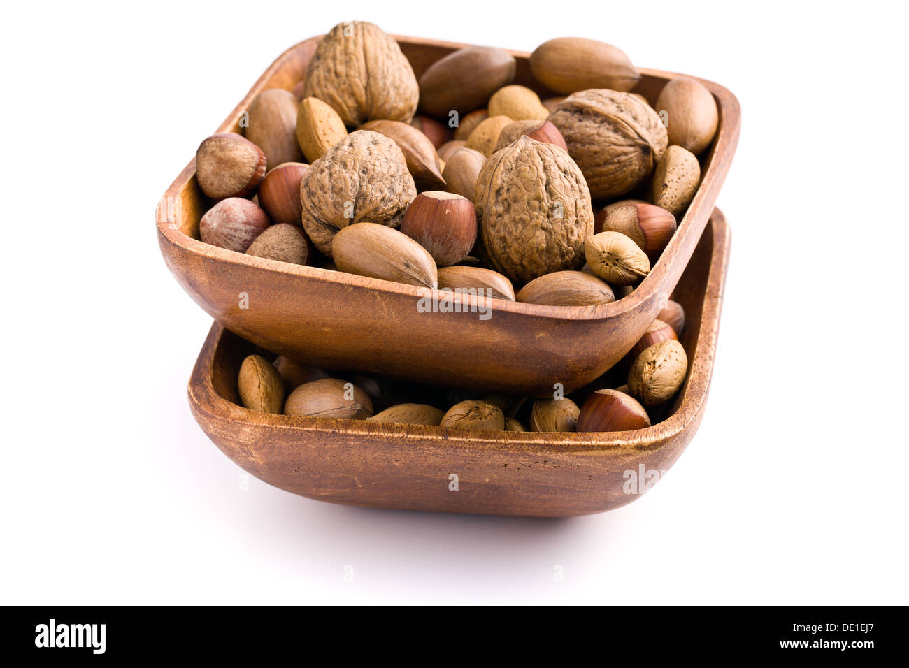various unpeeled nuts in wooden bowl on white background Stock Photo ...