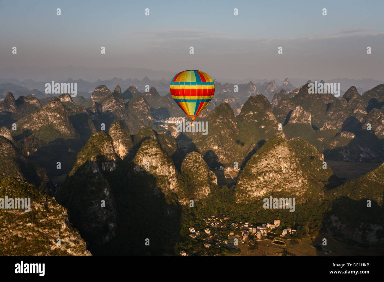 Colorful hot air balloon glides slowly above the knobby peaks of ...