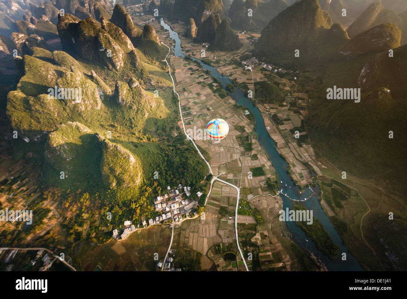 Hot air balloon floating above towns and rice fields in Li River Valley ...
