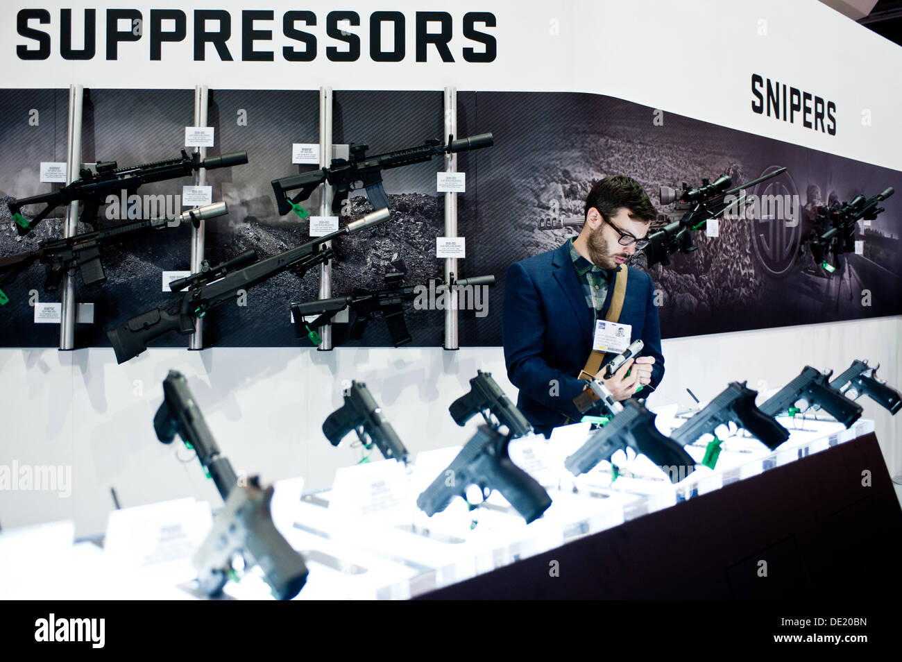 London, UK - 10 September 2013: a visitor looks at pistols on display ...