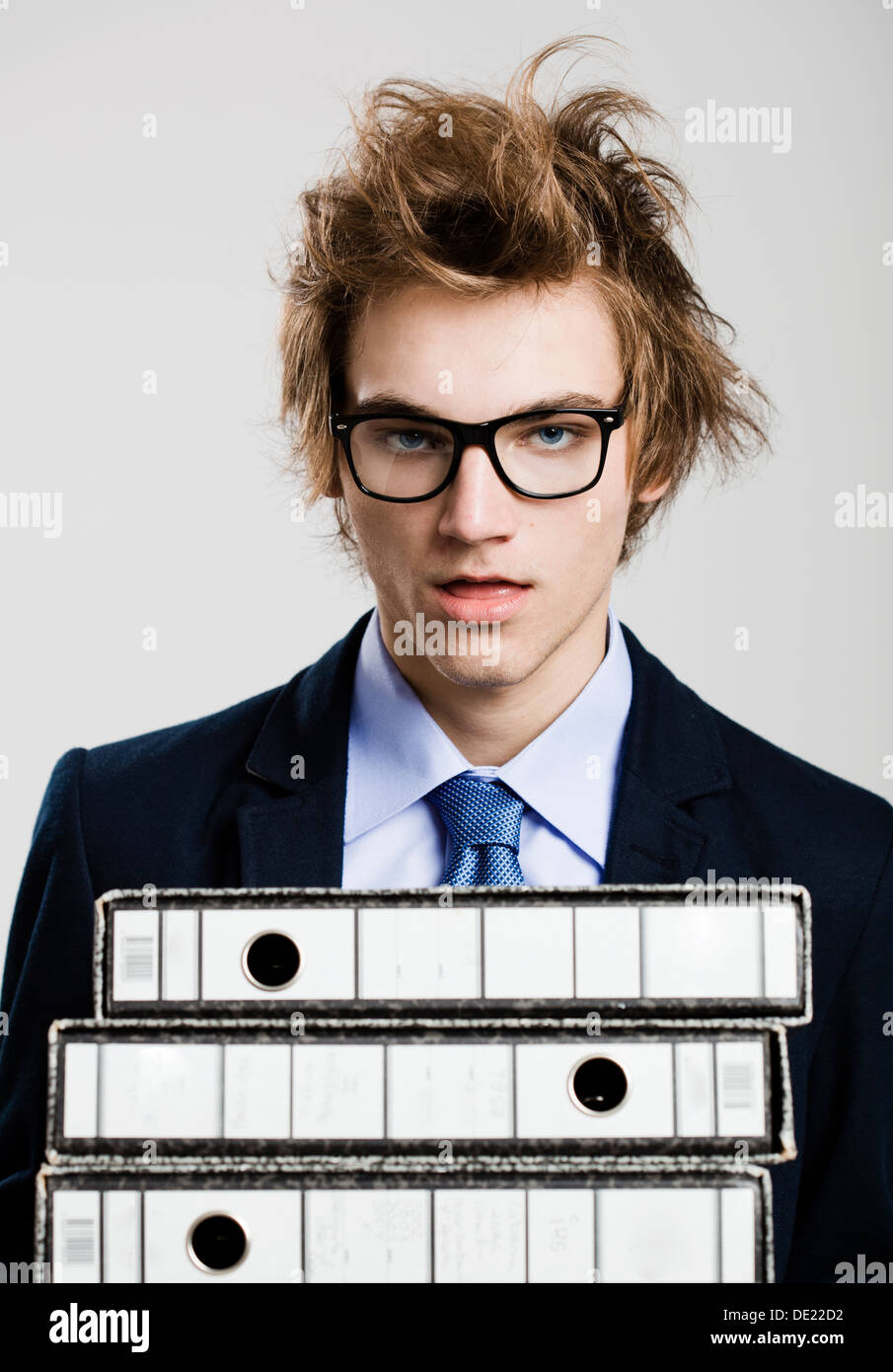 Young business man with nerd glasses and carrying a bunch of folders ...