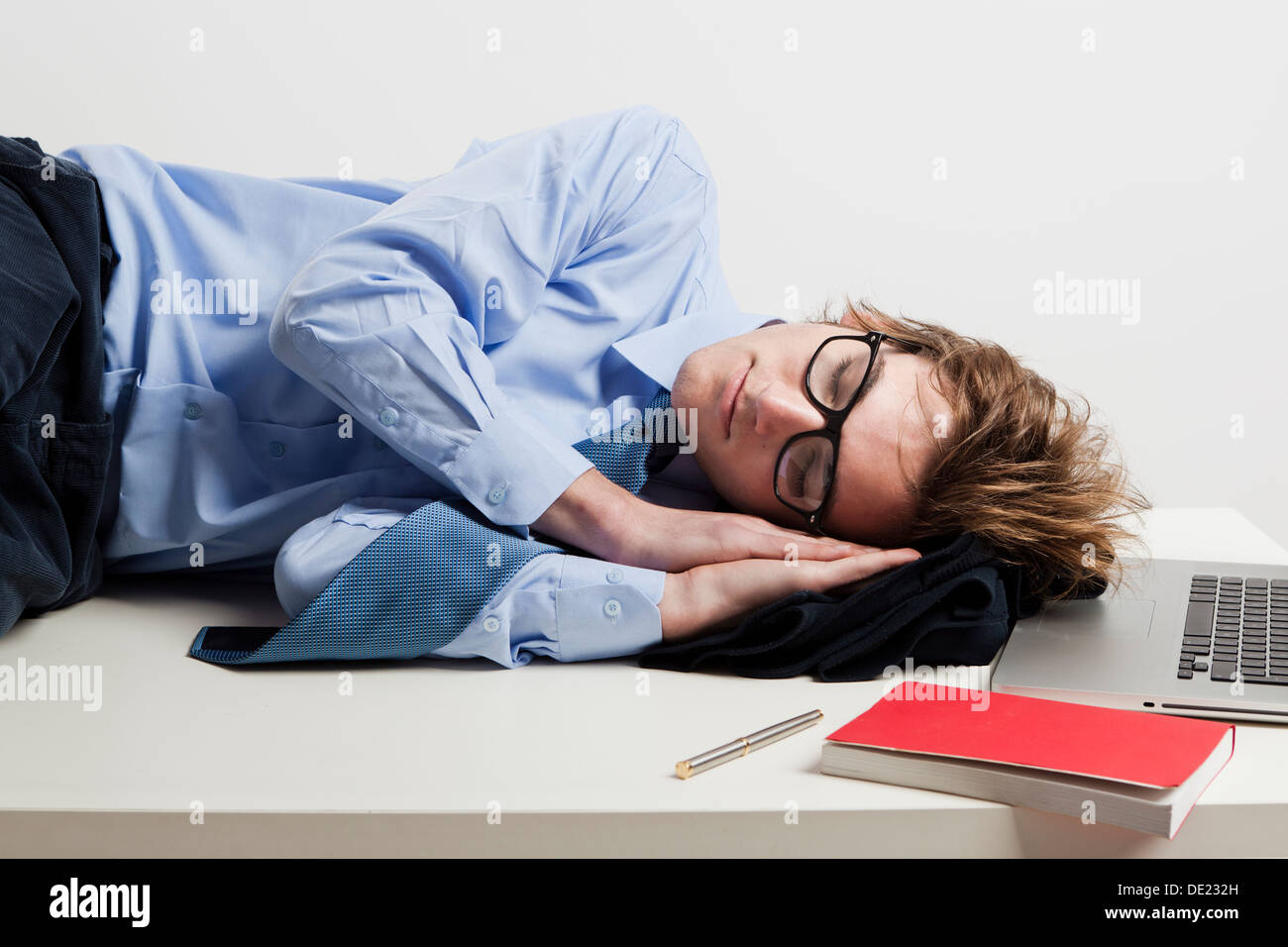 Young man in the office and sleeping over is desk Stock Photo - Alamy
