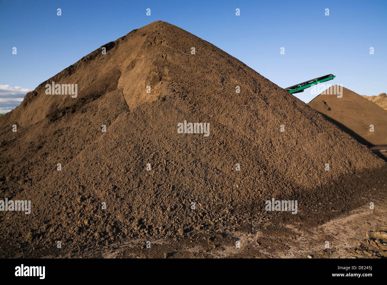Stacking conveyor and mounds of sand in a commercial sandpit, Quebec ...