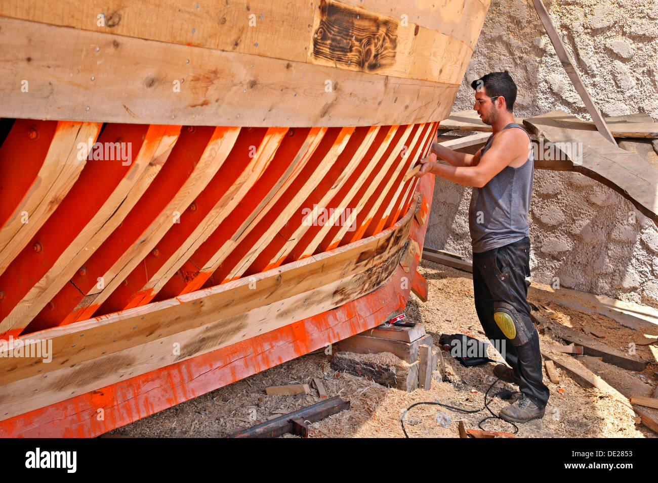Shipbuilder at the traditional shipyard of Agios Isidoros, Samos island ...