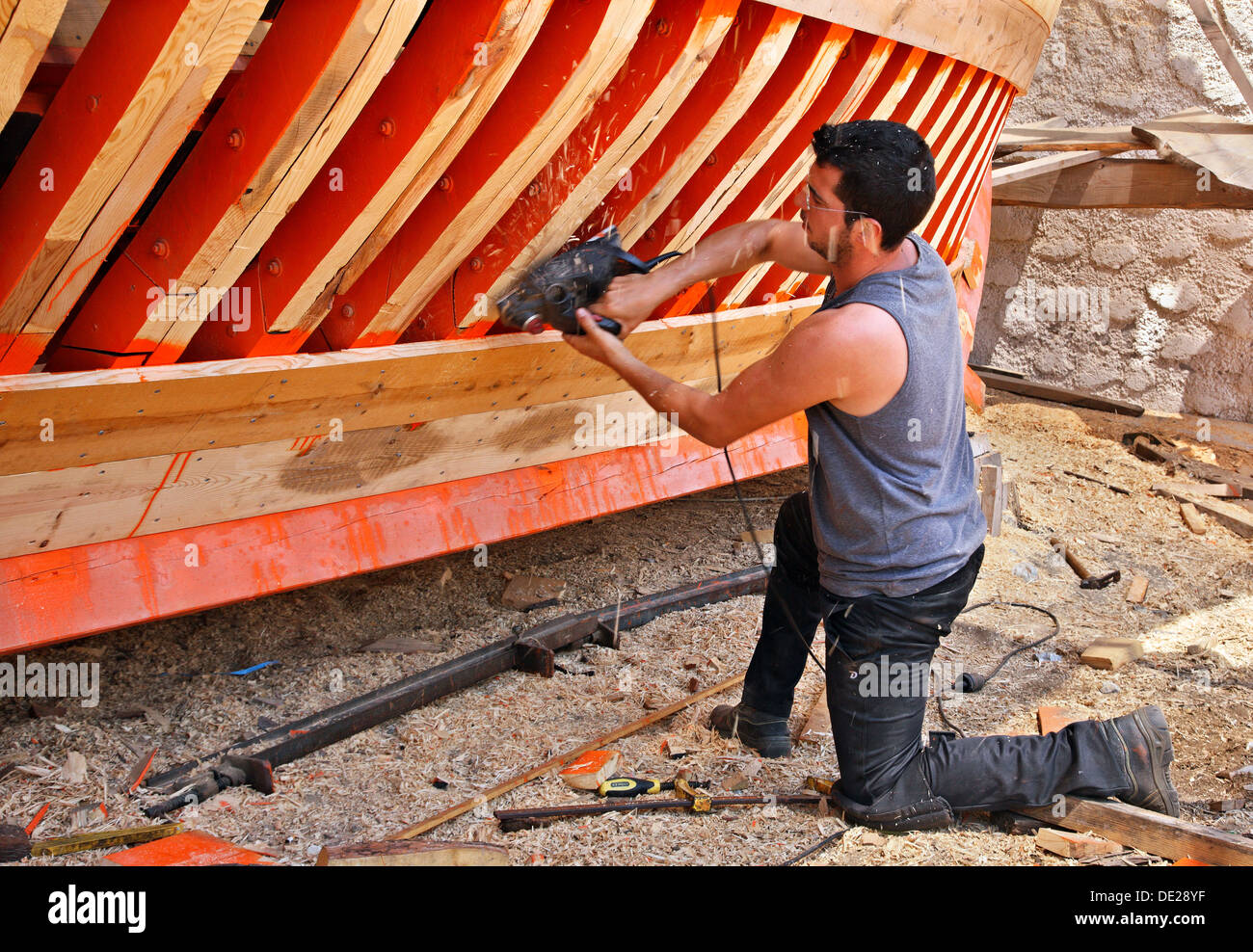 Shipbuilder at the traditional shipyard of Agios Isidoros, Samos island ...