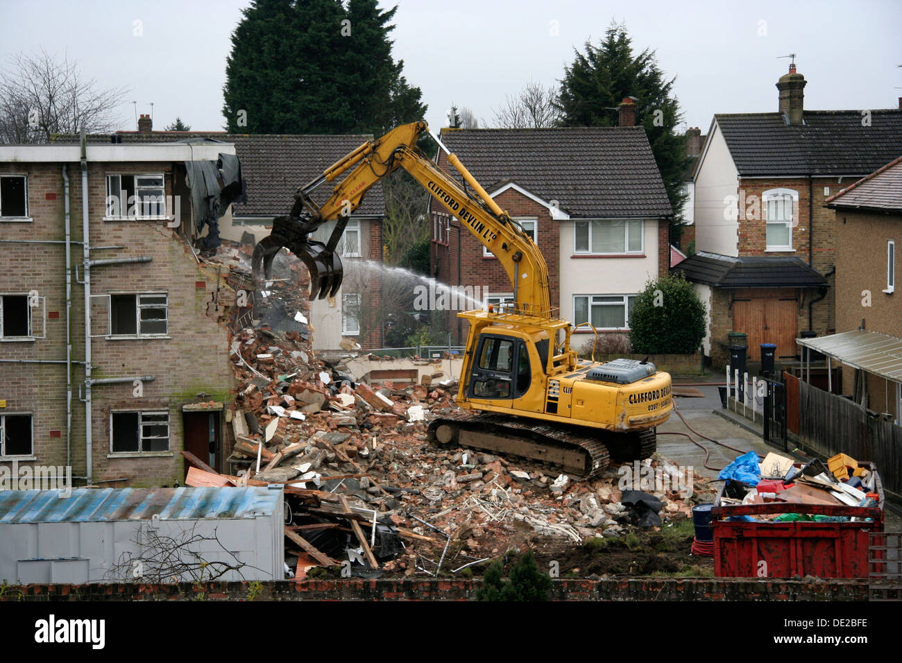 The Demolition of a Small block of Flats using an excavator. Water ...