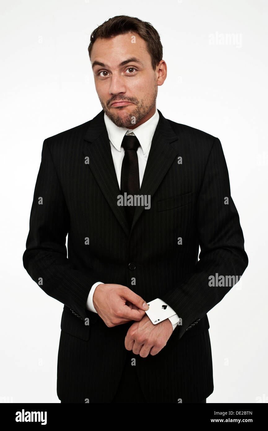 Man wearing a suit pulling an ace of spades out of his sleeve Stock ...