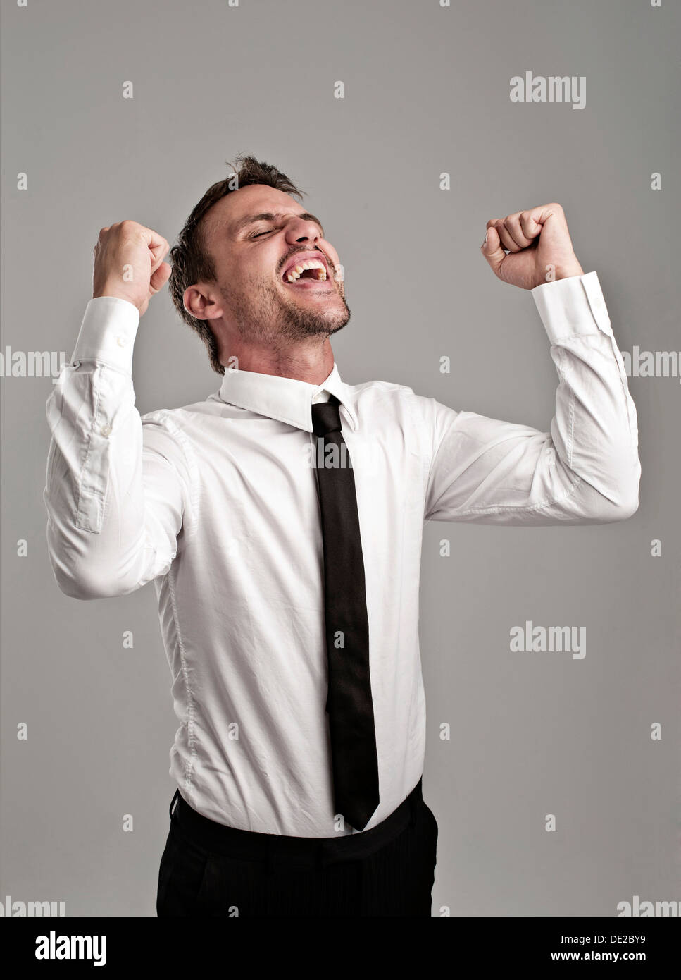 Young man wearing a shirt and a tie cheering, success, victory pose ...