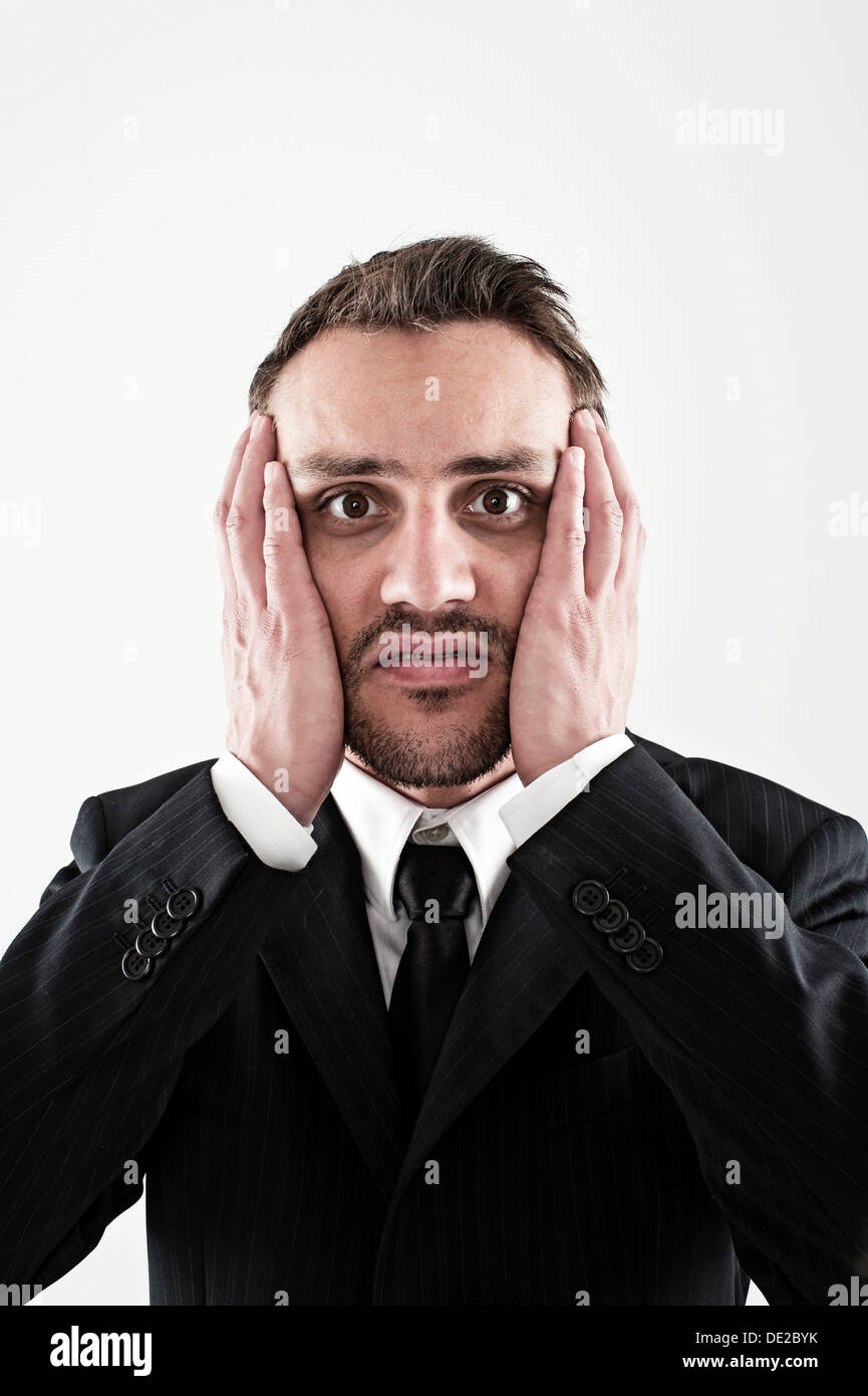 Desperate Young Man Wearing A Suit Holding His Hands To His Face