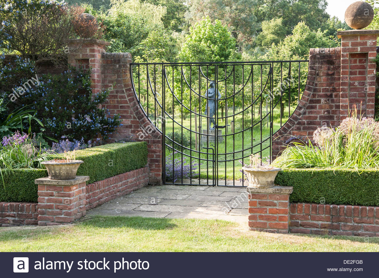 Wrought iron gate set into brick wall dviding the formal garden from ...