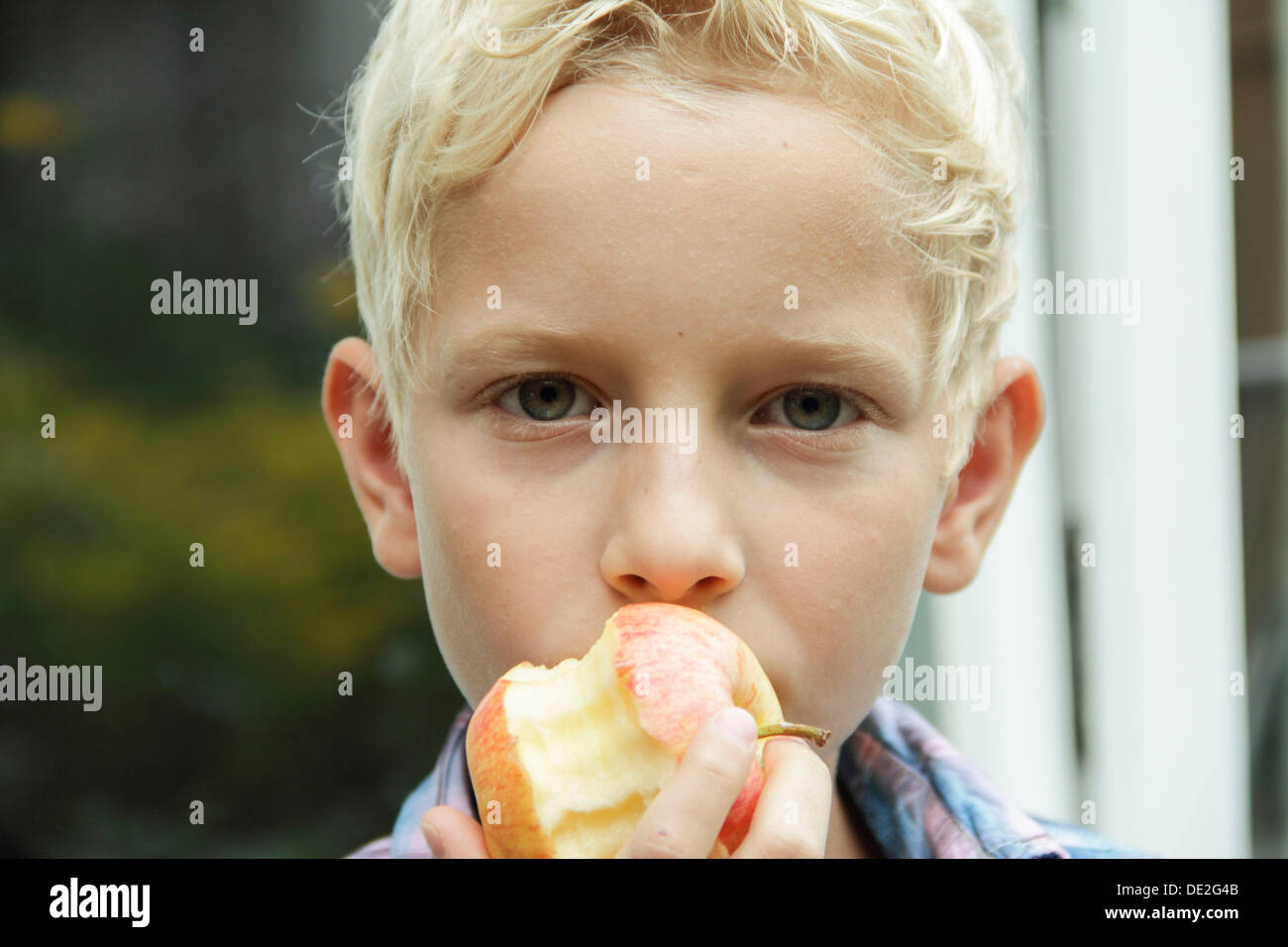 Boy eating an apple Stock Photo - Alamy