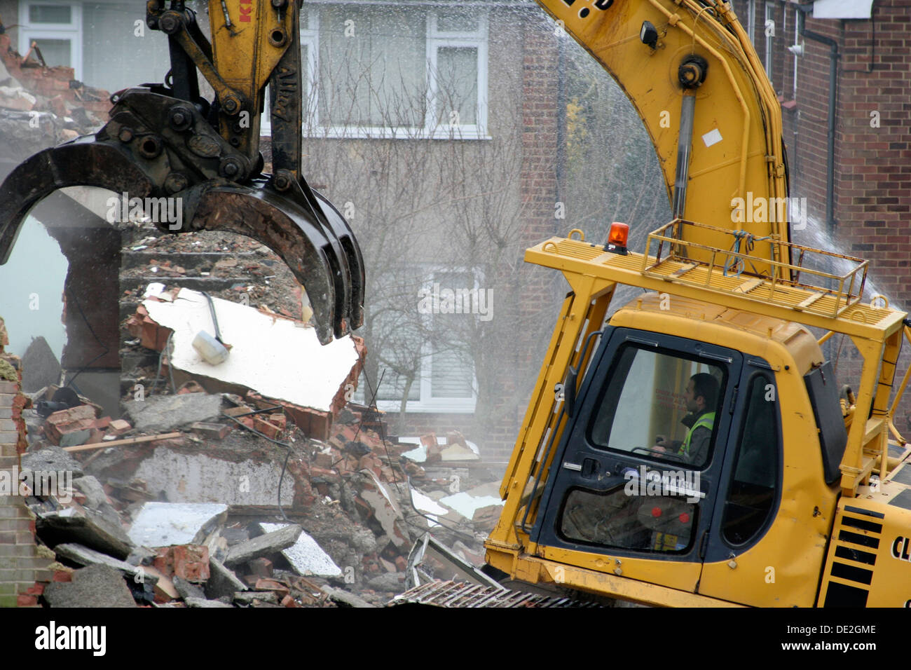 The Demolition of a Small block of Flats using an excavator. Water ...