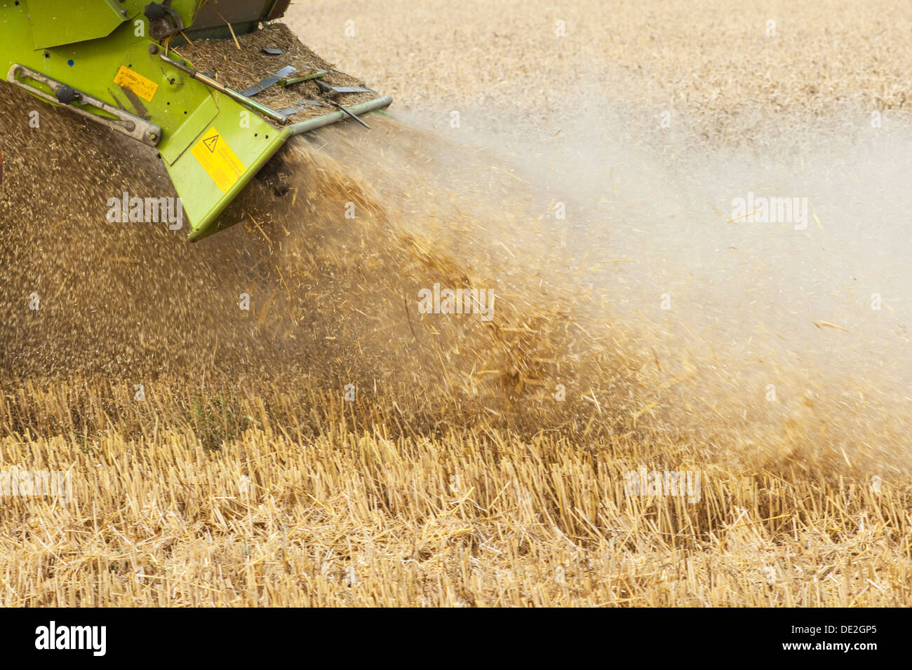 Waste material being ejected from the rear chute of a combine harvester ...