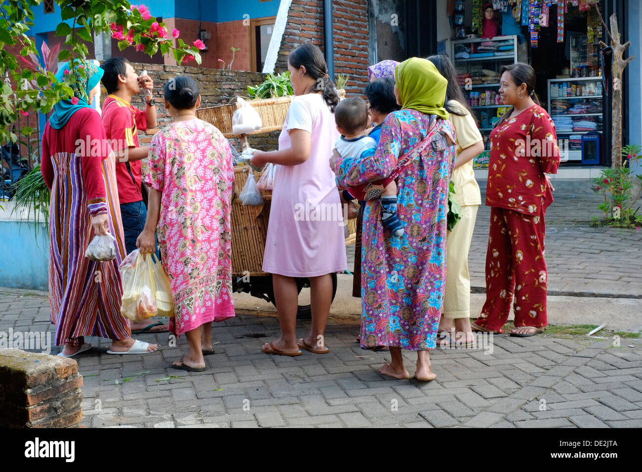 local village women crowd around a street vendor selling fresh ...