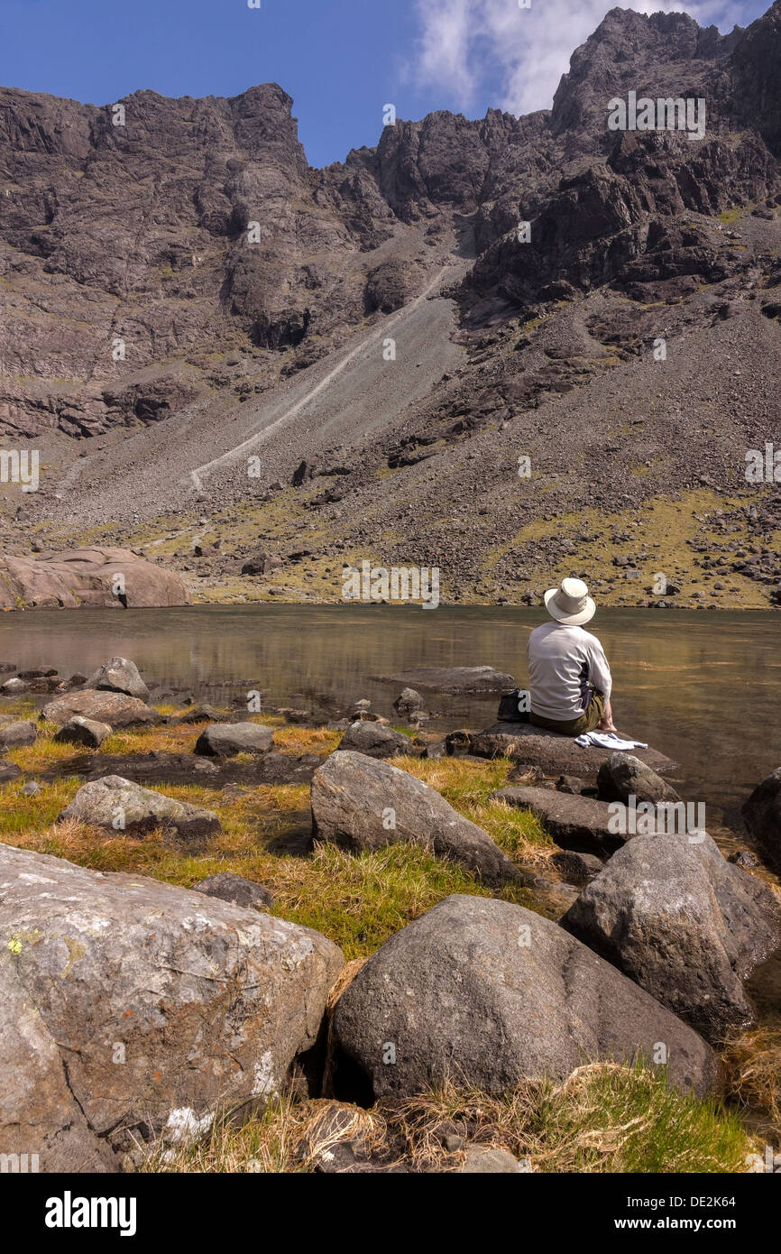 Woman in sun hat by loch admiring views of Coire Lagan, Great Stone ...