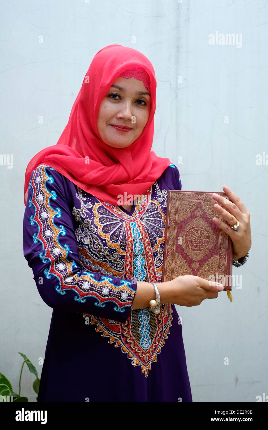 woman in full muslim dress holding a copy of the al koran Stock Photo ...