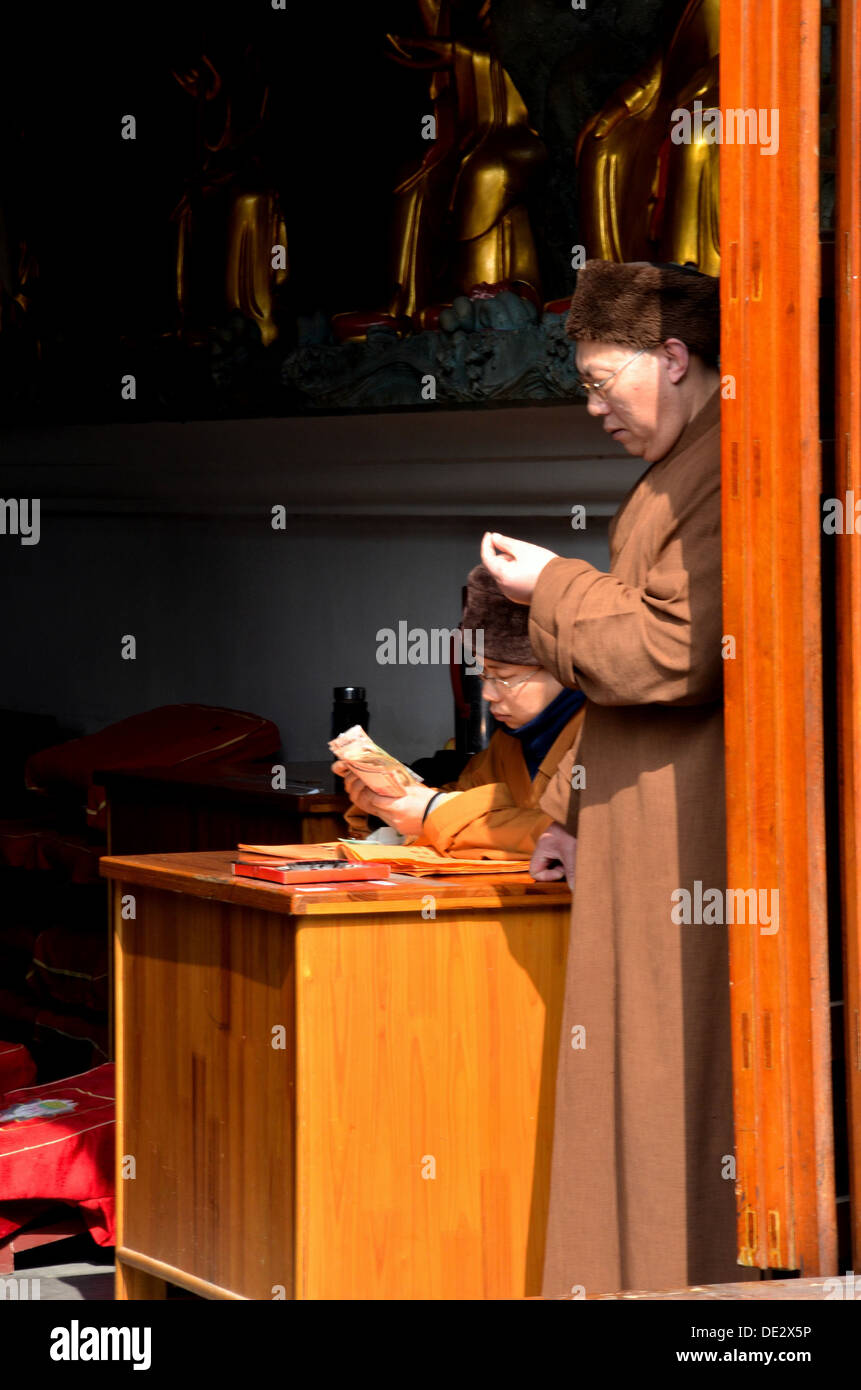 Chinese priests count donations at Shanghai temple Stock Photo - Alamy