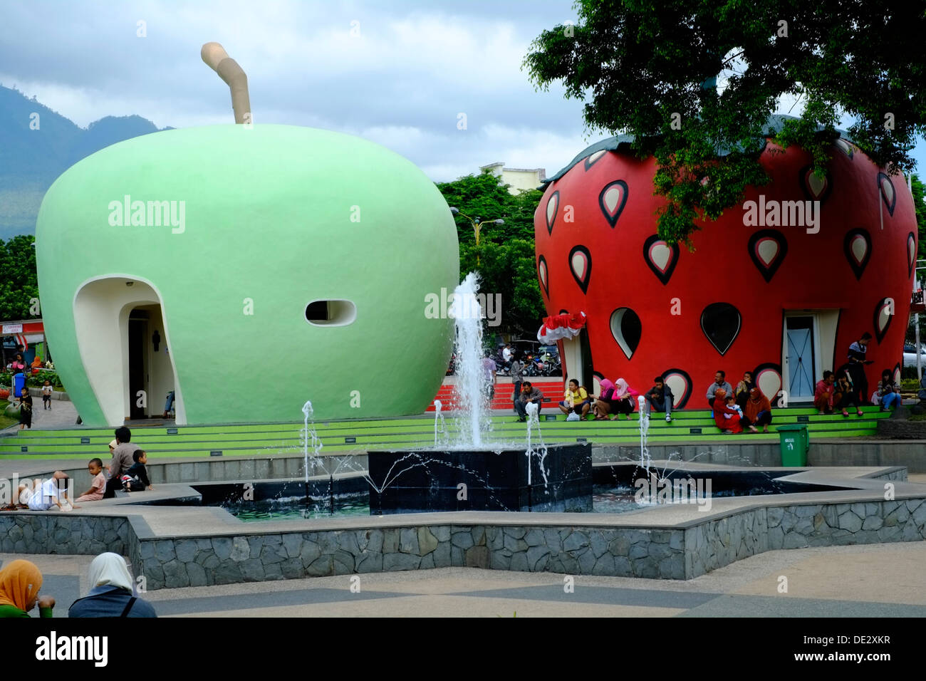 buildings in the shape of fruit with fountain at a small park in the ...