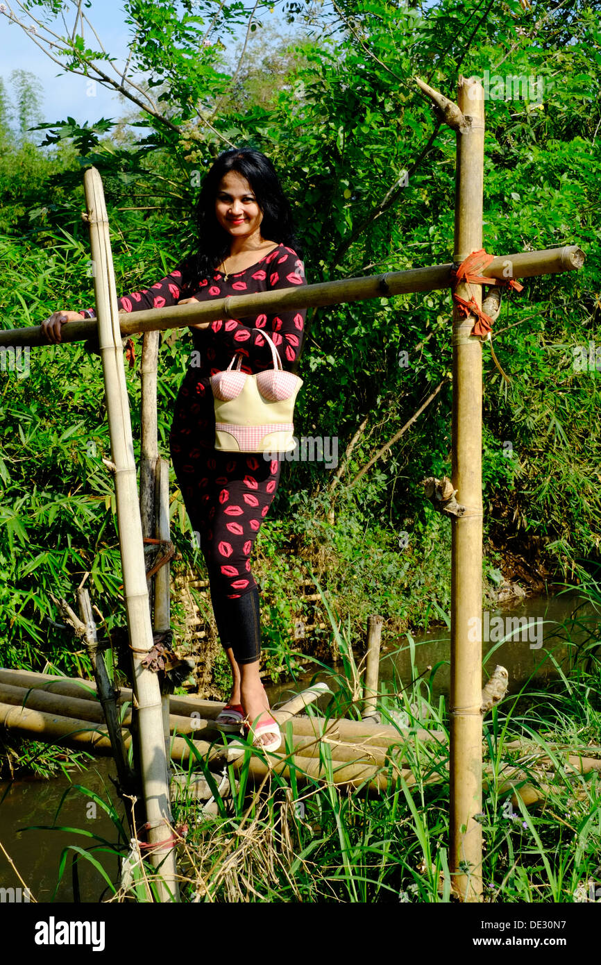 fashionable indonesian woman holding unusual handbag on her arm wearing ...