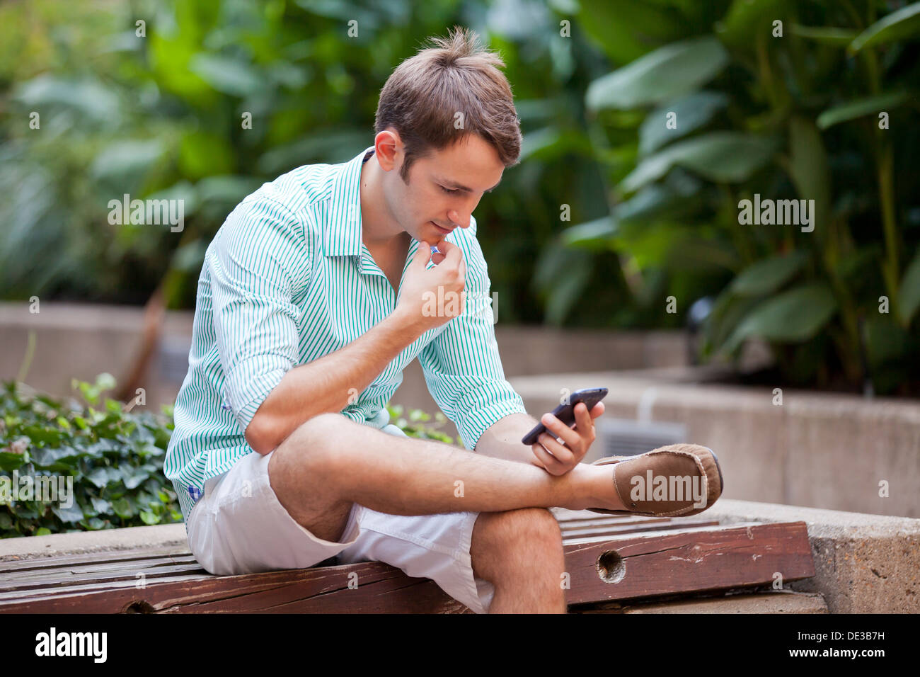 Sitting man checking phone hi-res stock photography and images - Alamy