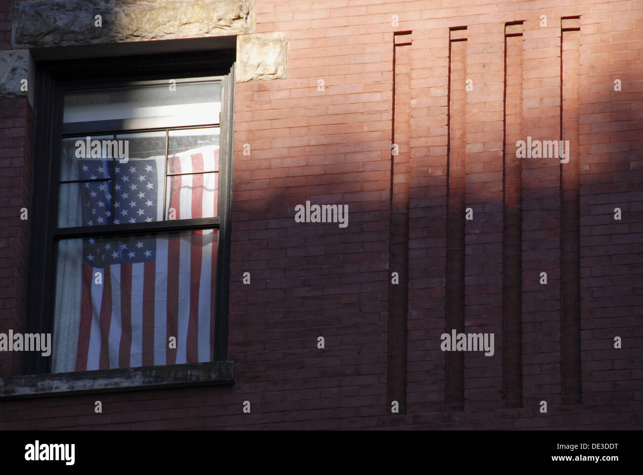 American flag displayed in a 6th floor window Stock Photo - Alamy