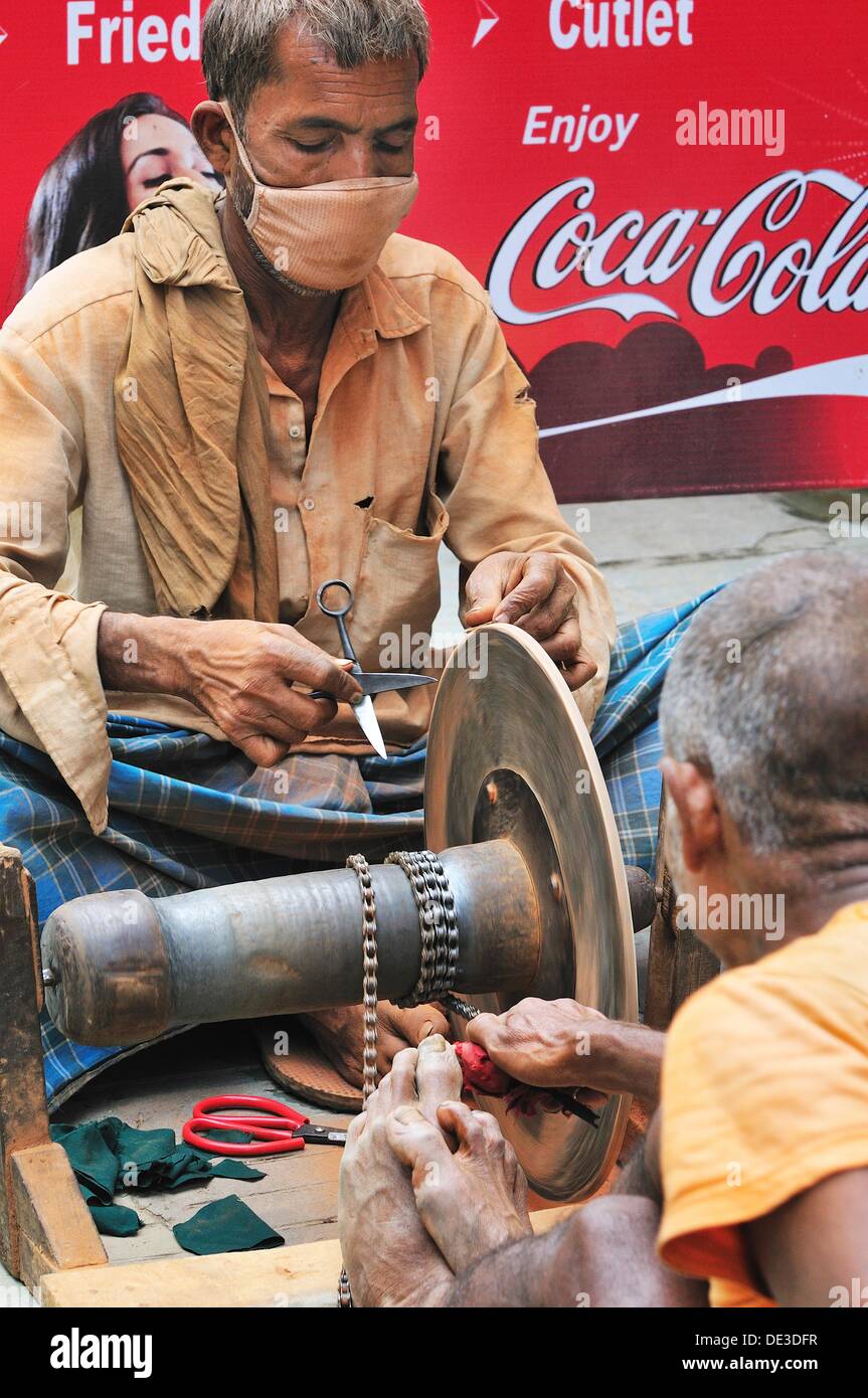 Two men working sharpening scissors on the street in Durbar square ...