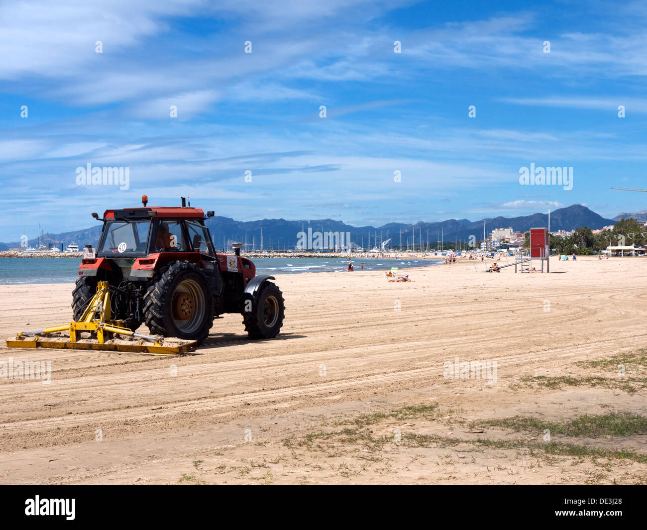 Tractor smoothing the sand out on a beach Stock Photo - Alamy