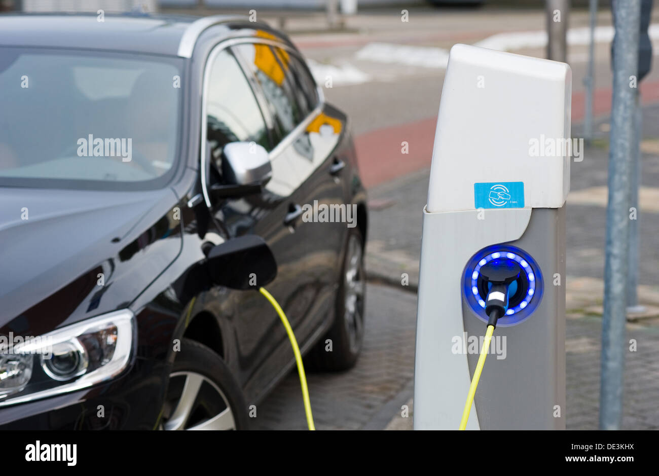 An electric car charging at a power station Stock Photo - Alamy