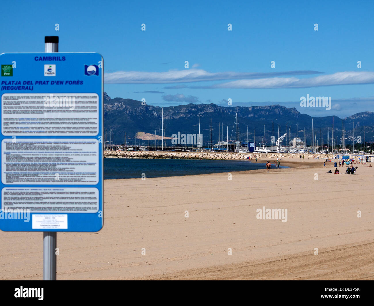 Beach information sign in spanish with the sand and water in the ...