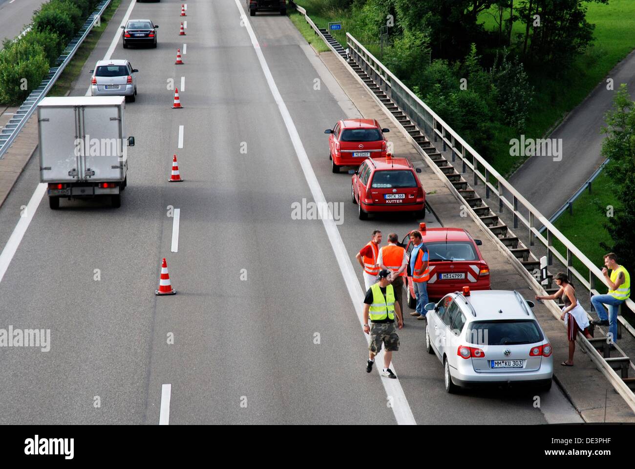 Construction site workers wait on the hard shoulder of the highway ...